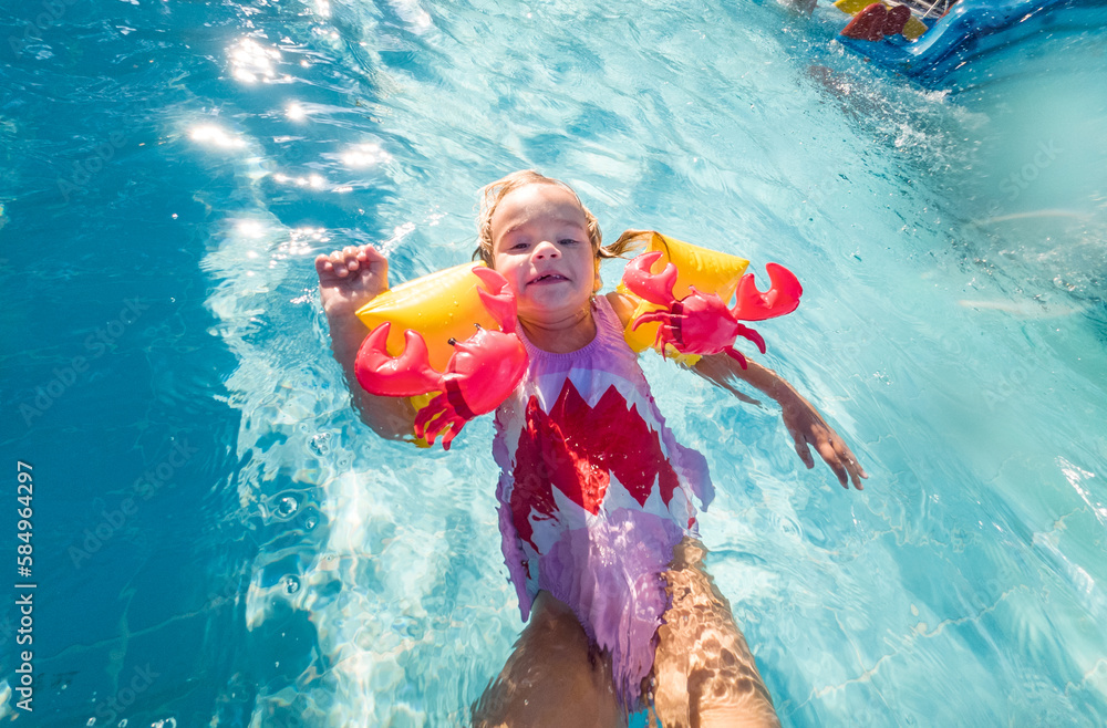 cute girl floating on back in the swimming pool Stock Photo | Adobe Stock