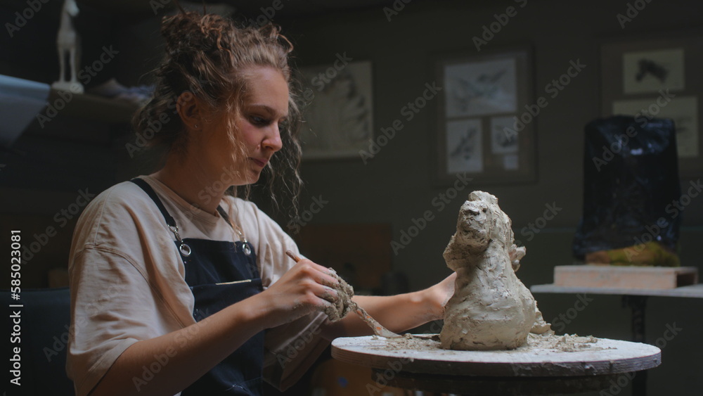 European blonde girl sculptor creates sculpture, statue for interior ...