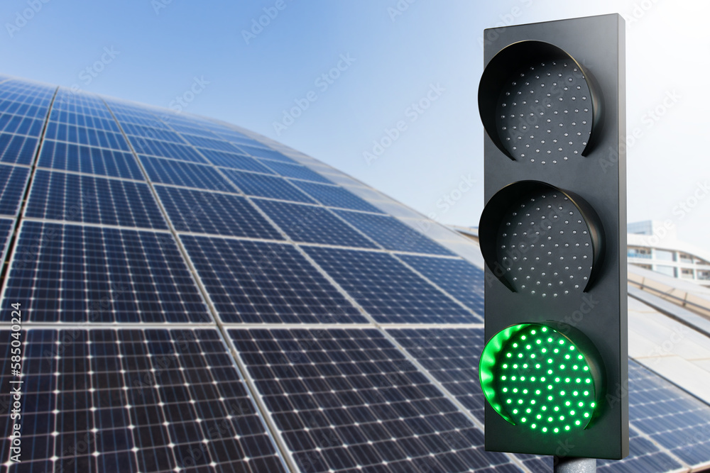 Green traffic light on a background of solar panels. Symbol of ...
