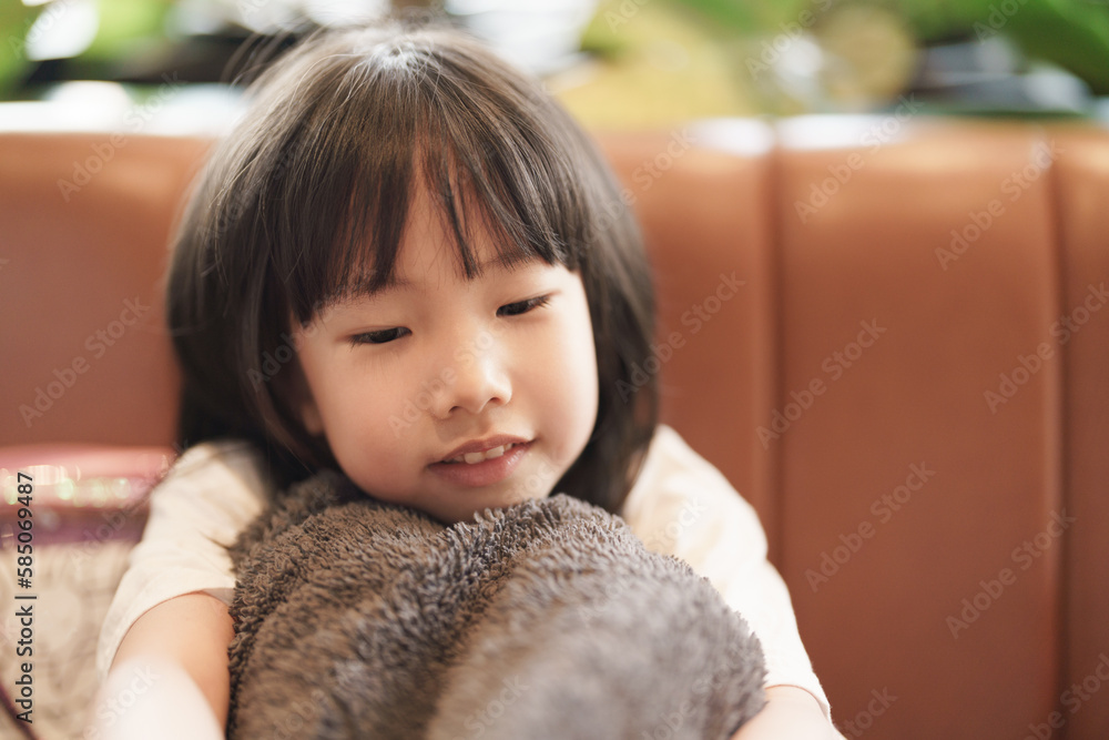 Cute Asian girl sitting at the sofa smiling feeling relax while hugging ...