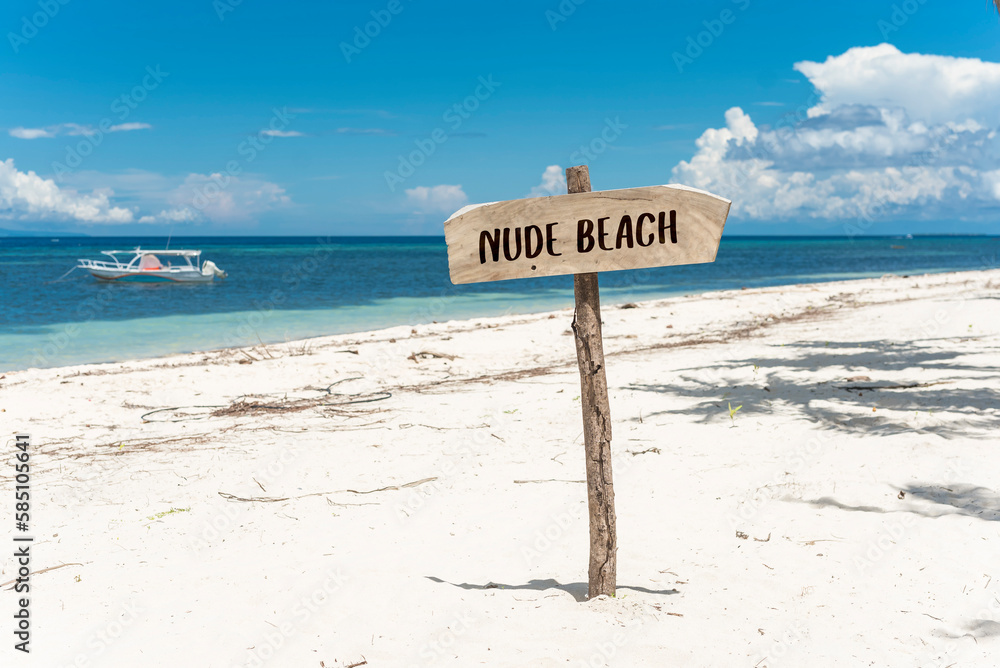 A nude beach sign posted at the beachfront. A nudist beach or naturist ...