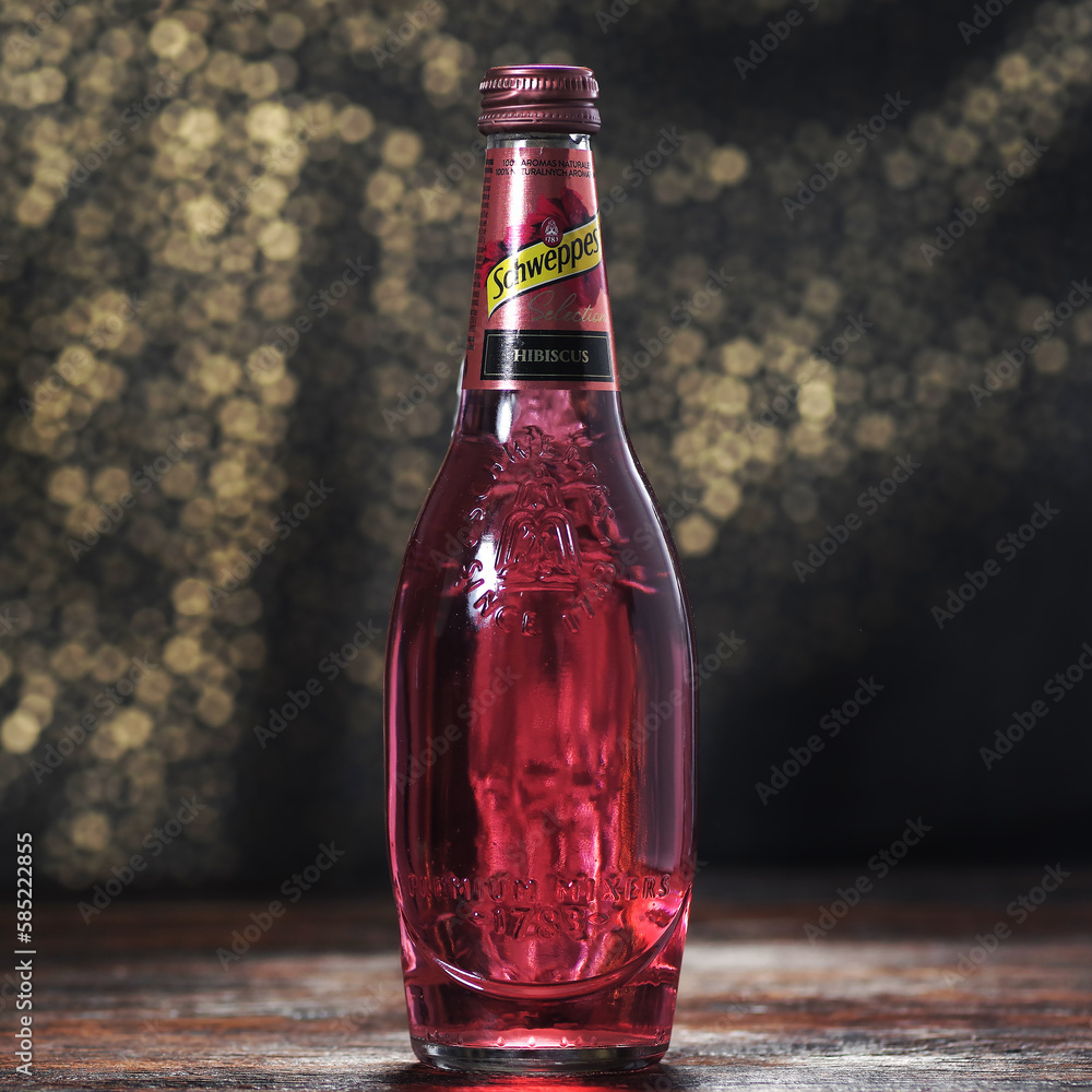 Koszalin, Poland, March 25, 2023. Schweppes Glass bottle on an abstract ...