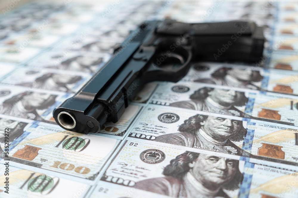 black gun on the background of cash dollars. concept of criminal money ...