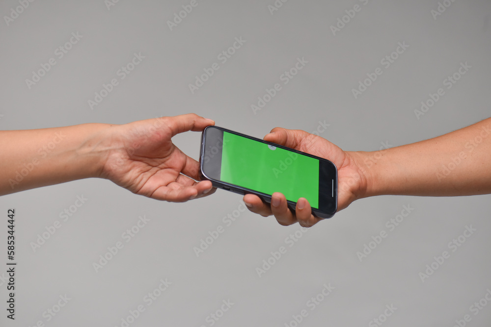 Two people handing smartphones to each other for communication purposes ...