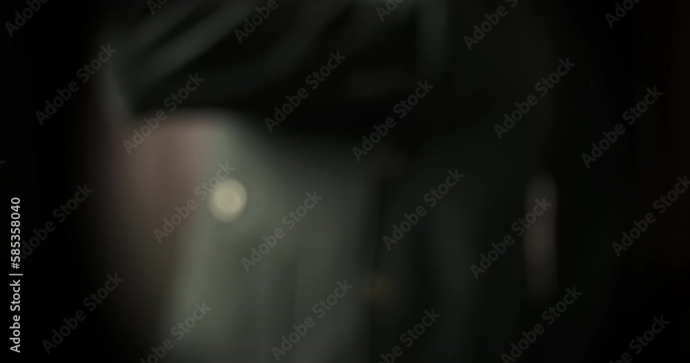 Man rotates an LED light bulb in his hands, made under an incandescent ...