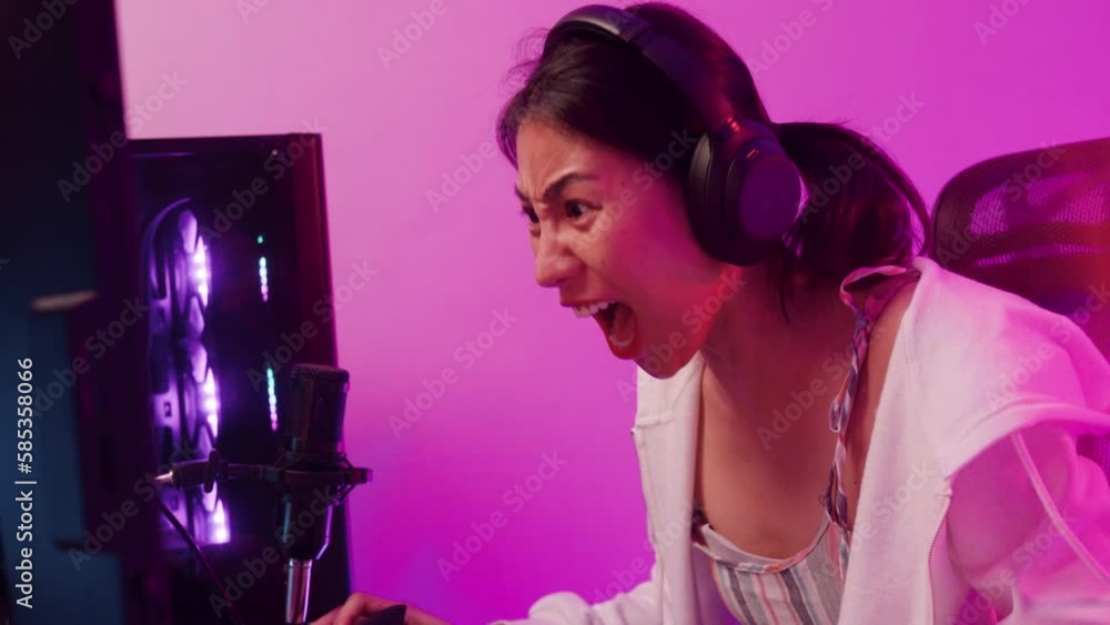 Young Asia female online video game addict sit on gaming chair wear ...