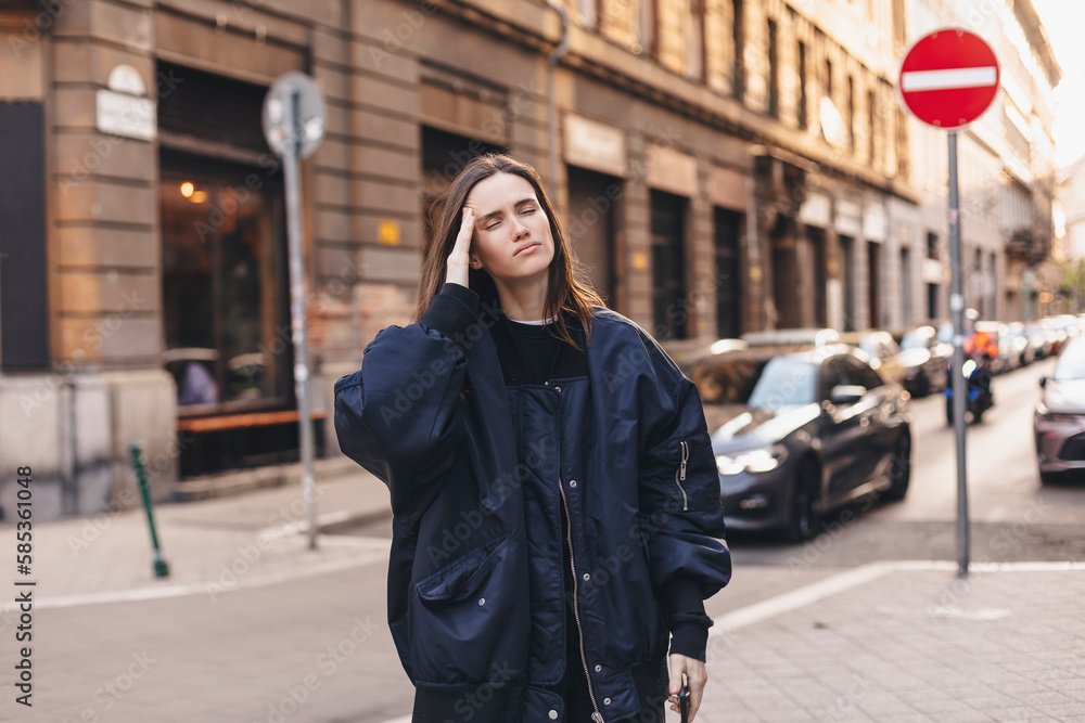 Foto de Panic attack on the street. Female touch her head with her ...