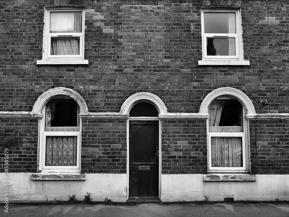 front view of a typical old brick british terraced house with white ...