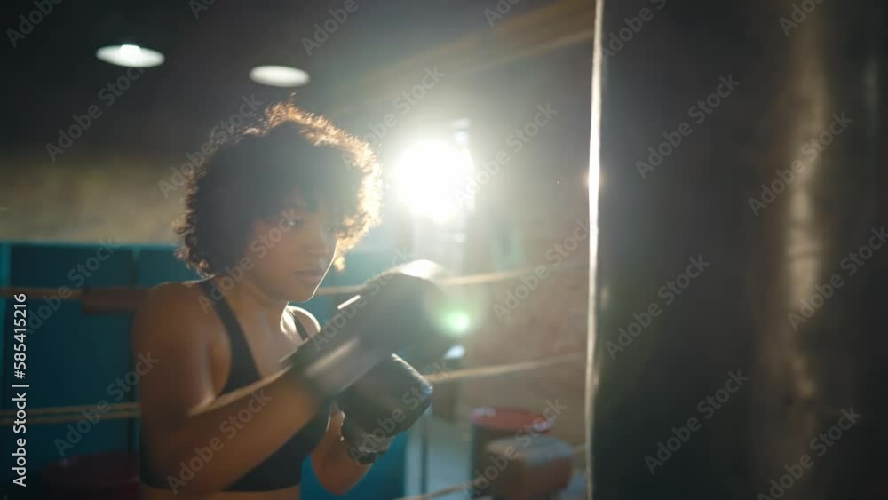 Portrait of afro american woman boxer with curly hair boxing in gym on ...