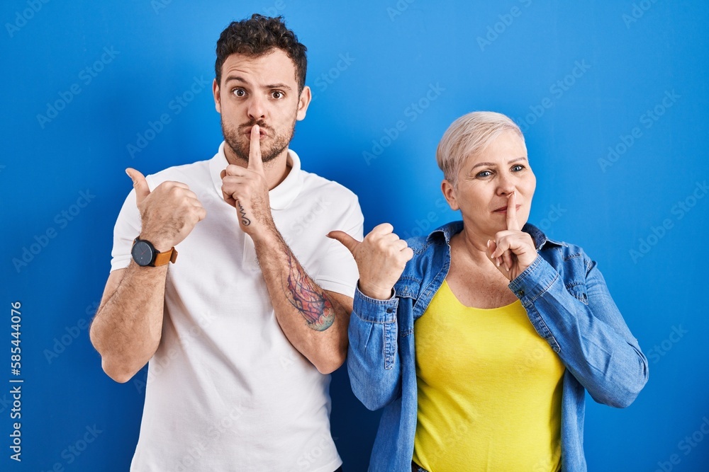 Young brazilian mother and son standing over blue background asking to ...