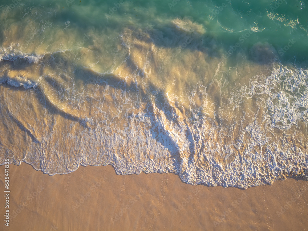 Sea wave on the sandy shore. Beautiful turquoise water and white lacy ...