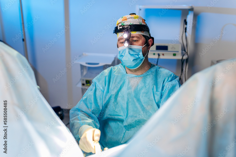 Professional male surgeon proctologist performing operation using ...