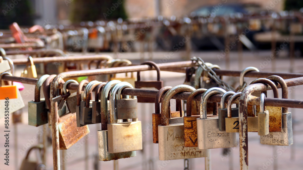 many locks attached to the metal fence of the river walk. A close up ...