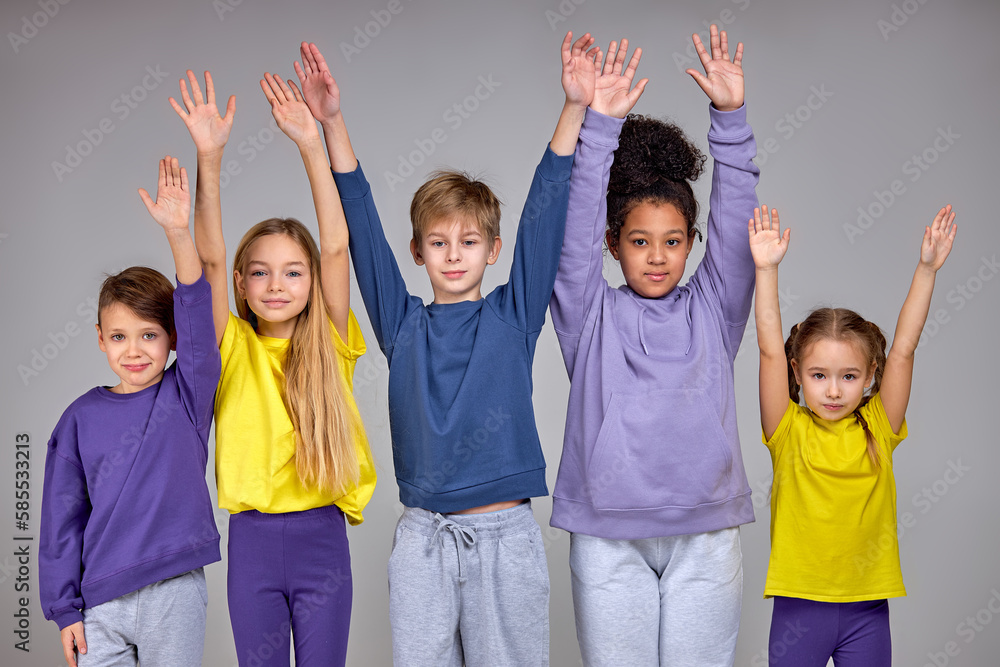 diverse happy children raising their hands, arms looking at camera ...