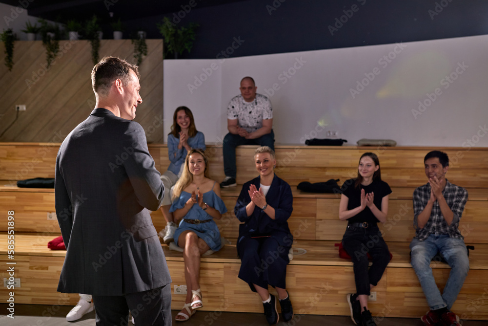 group of young people clapping hands after listening the conference in ...