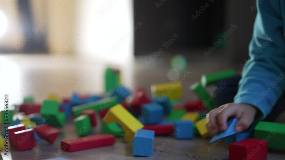 Kid accidentally destroying tower of buildings blocks. Child playing ...