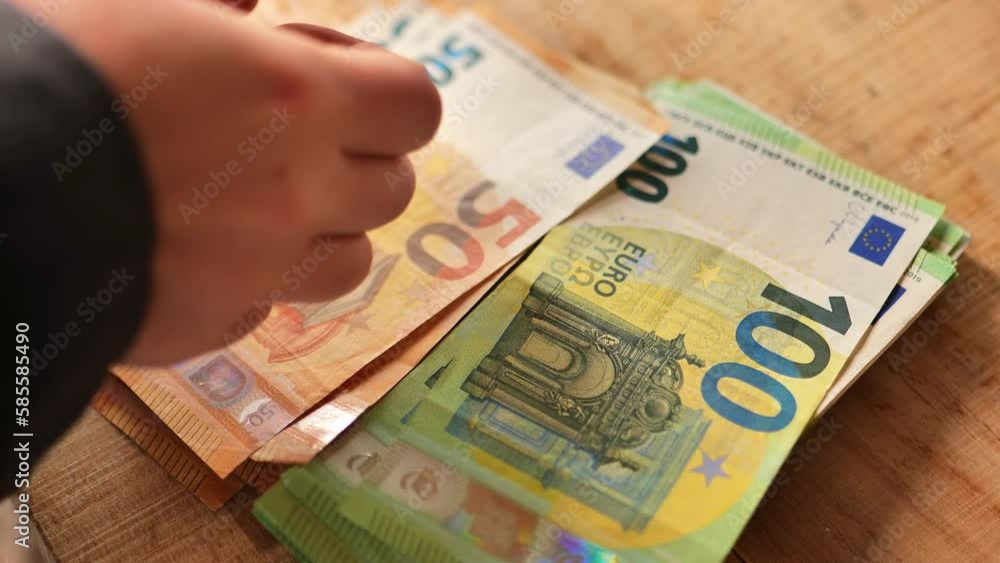 Counting euro banknotes.Hands recalculate banknotes on wooden table ...