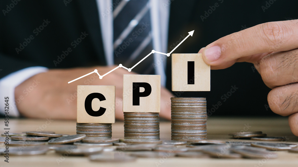 CPI, consumer price index symbol. hand holding wooden block with words ...