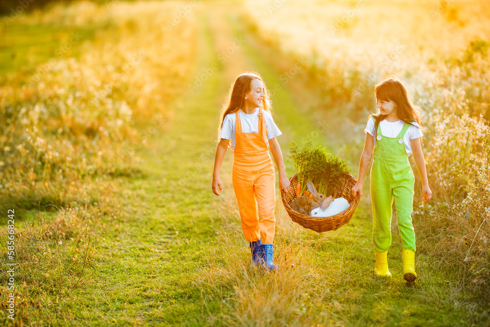 Two cheerful little girls help take care of the animals on the farm ...