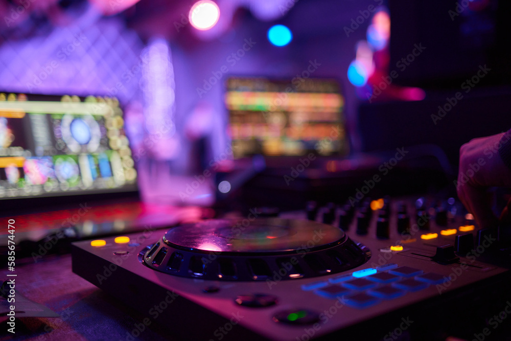 An expert adjusting audio mixing console with white blank screen laptop ...