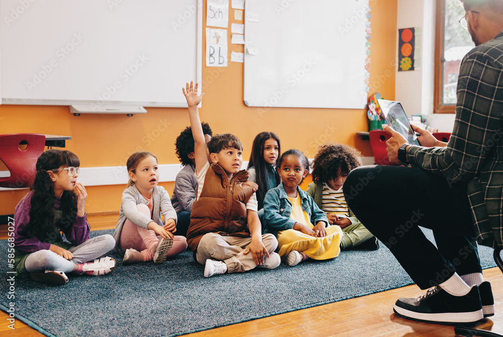 Boy raises his hand to answer a question in a classroom Stock Photo ...