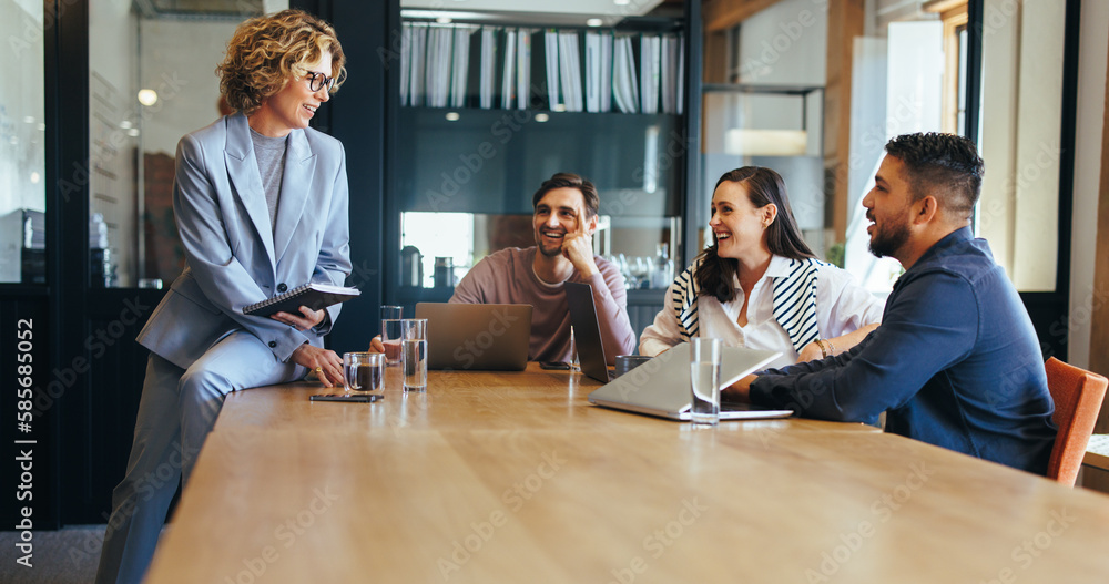 Foto de Group of tech professionals having a meeting in a boardroom do ...