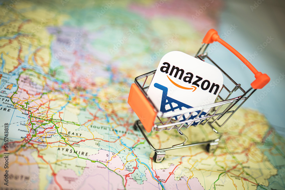 Amazon logo in a small shopping trolley over UK map. Online shopping ...