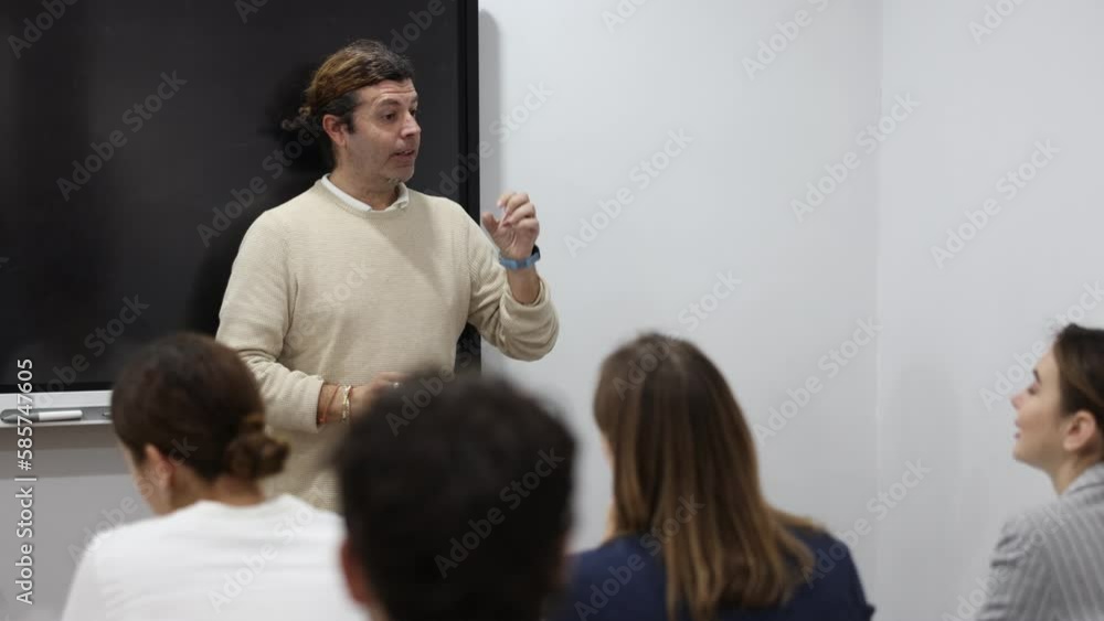Experienced male teacher giving lecture to group of student ...