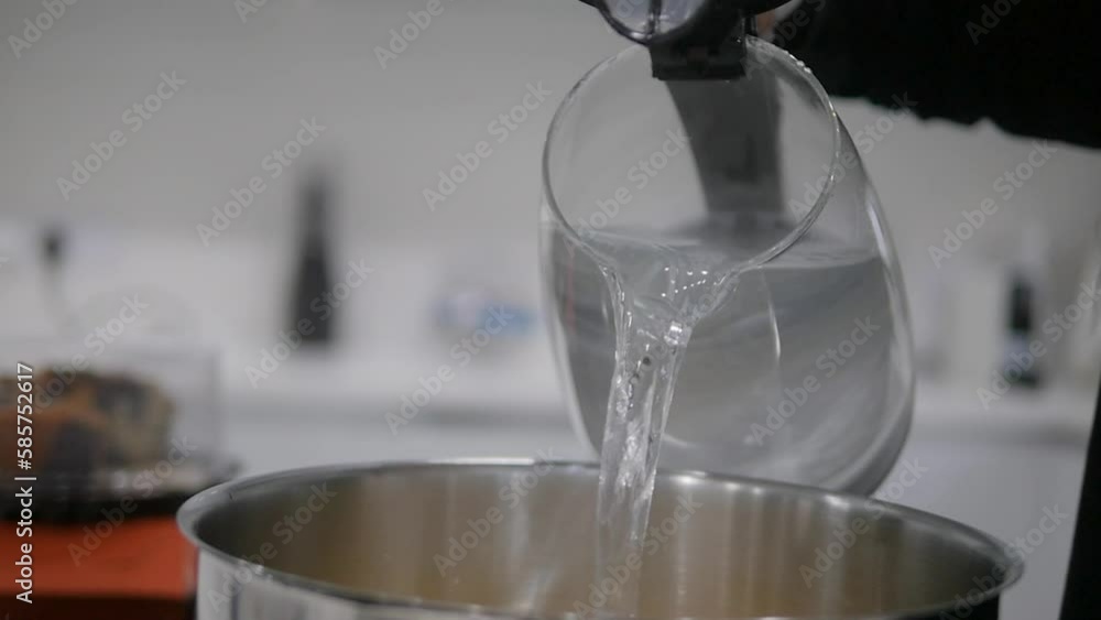 Pouring boiling water from a kettle into a pot while cooking. Stock ビデオ ...