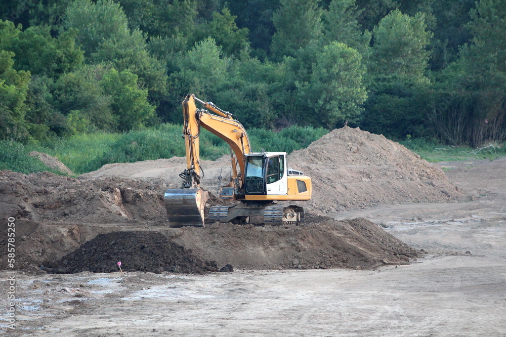 Industrial crawler excavator on top of dirt pile at local road ...