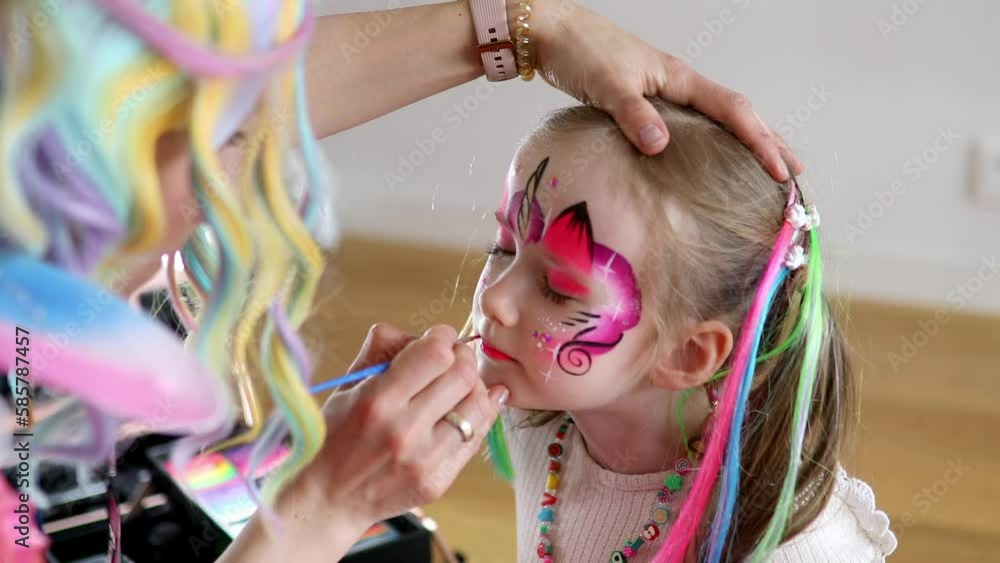 Children face painting. Artist painting little preschooler girl like ...