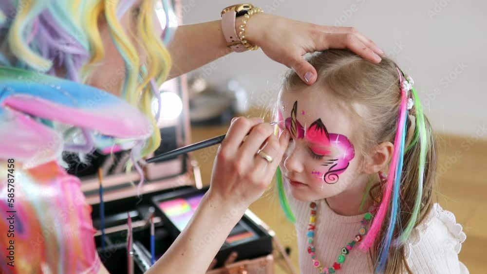 Children face painting. Artist painting little preschooler girl like ...