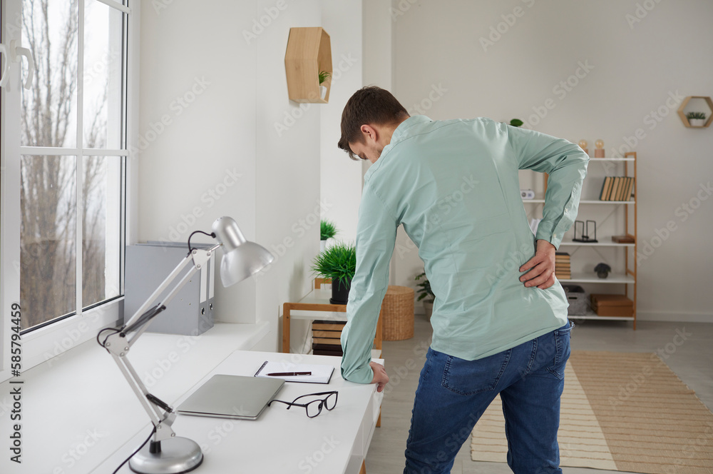 Rear view young man suffering from backache in ofiice. Tired office ...