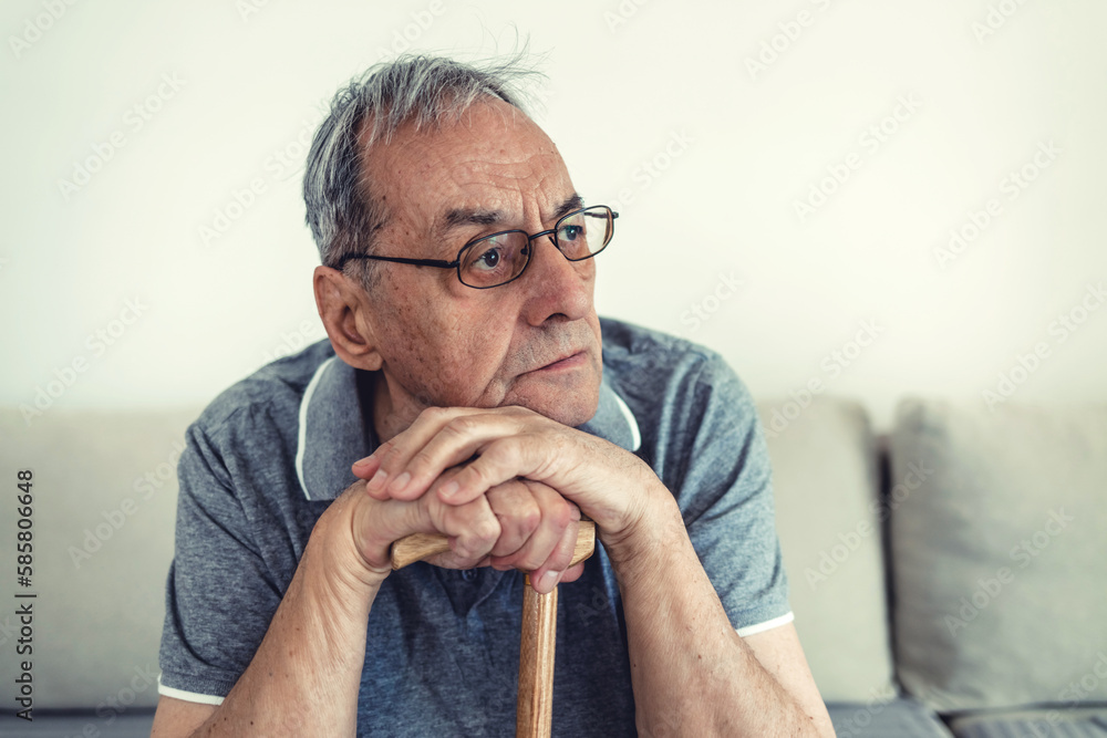 Shot of a senior man leaning in his walking stick at home. Hands of a ...
