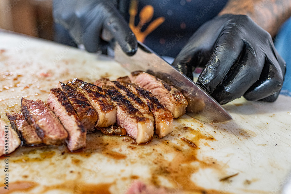 Foto de Assador cortando carne assada na grelha na brasa da parrilla do ...