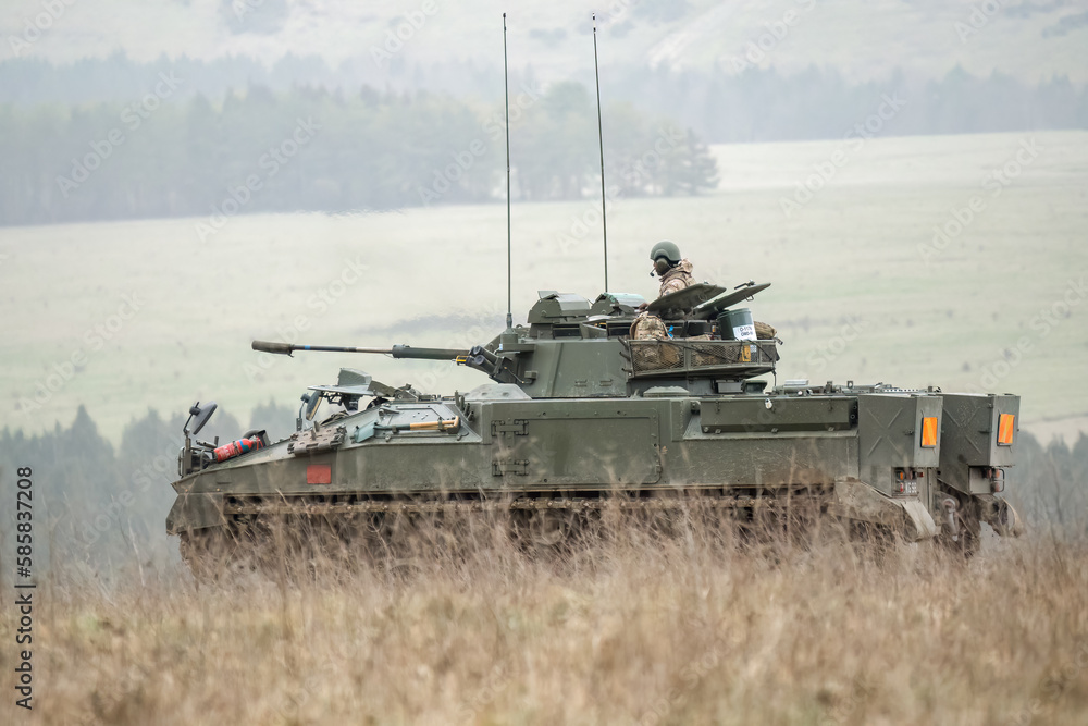 British army Warrior FV510 with commander in action, moving across ...