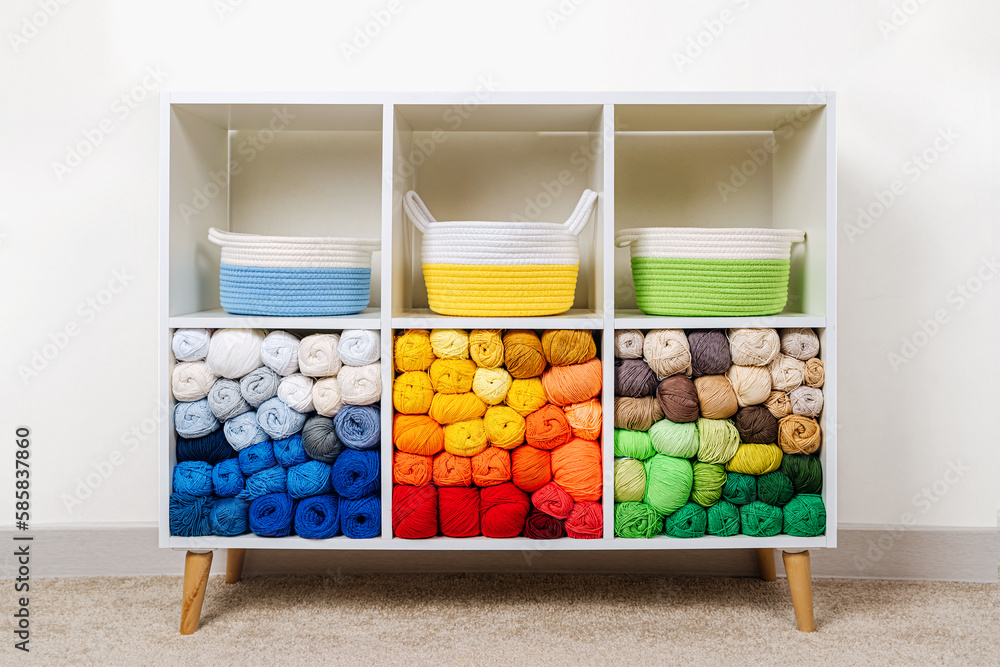 Shelving with storage baskets and colored balls of yarn for knitting ...