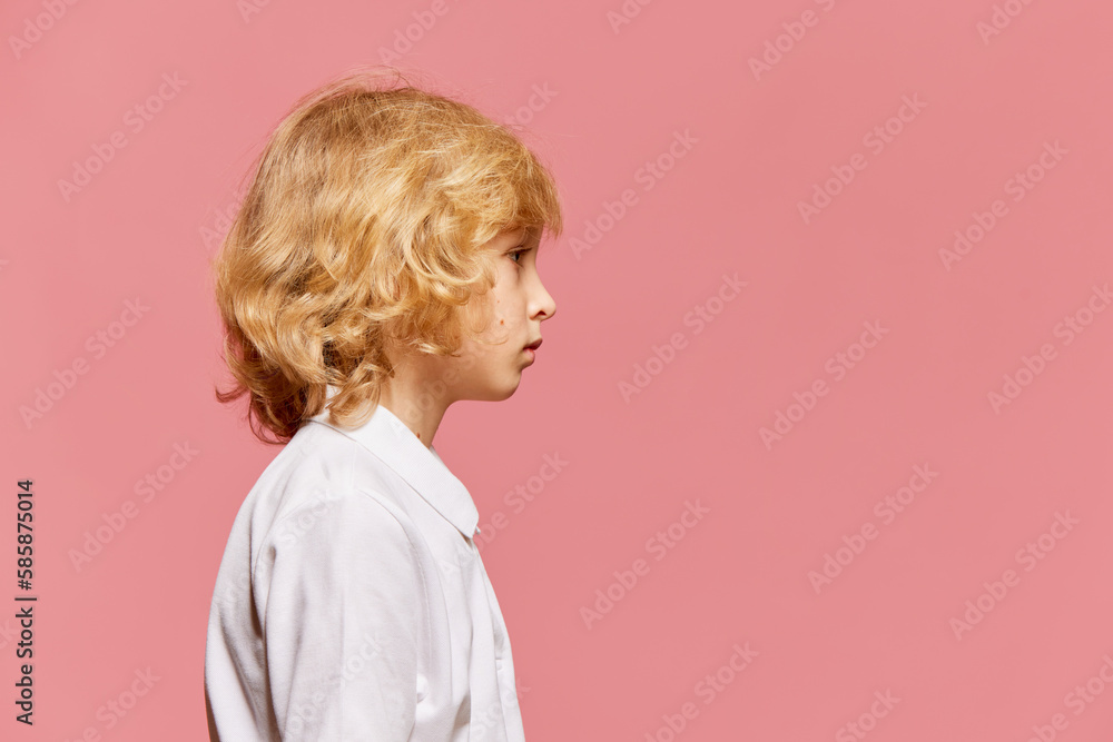 Side view portrait of little boy, child with curly blonde hair in white ...