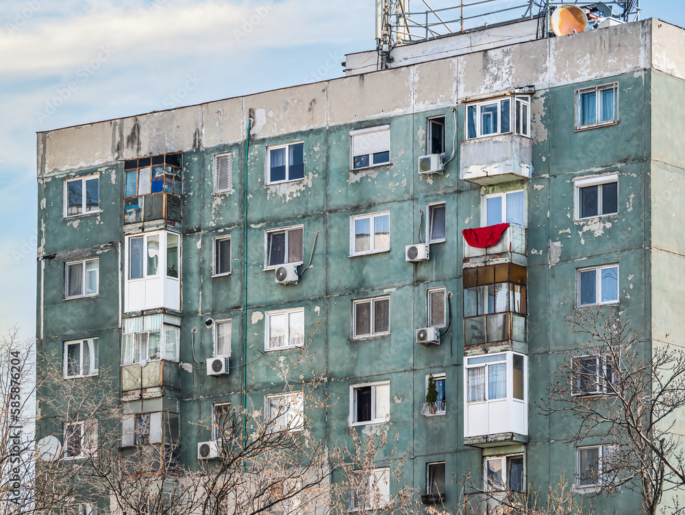 Worn out apartment building from the communist era against blue sky in ...