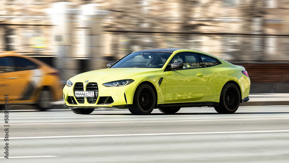 BMW M4 Competition G82 car is driving down the street. Front side view ...