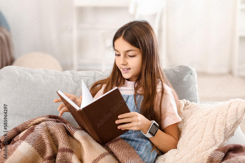 Little girl with smartwatch reading book at home Stock Photo | Adobe Stock