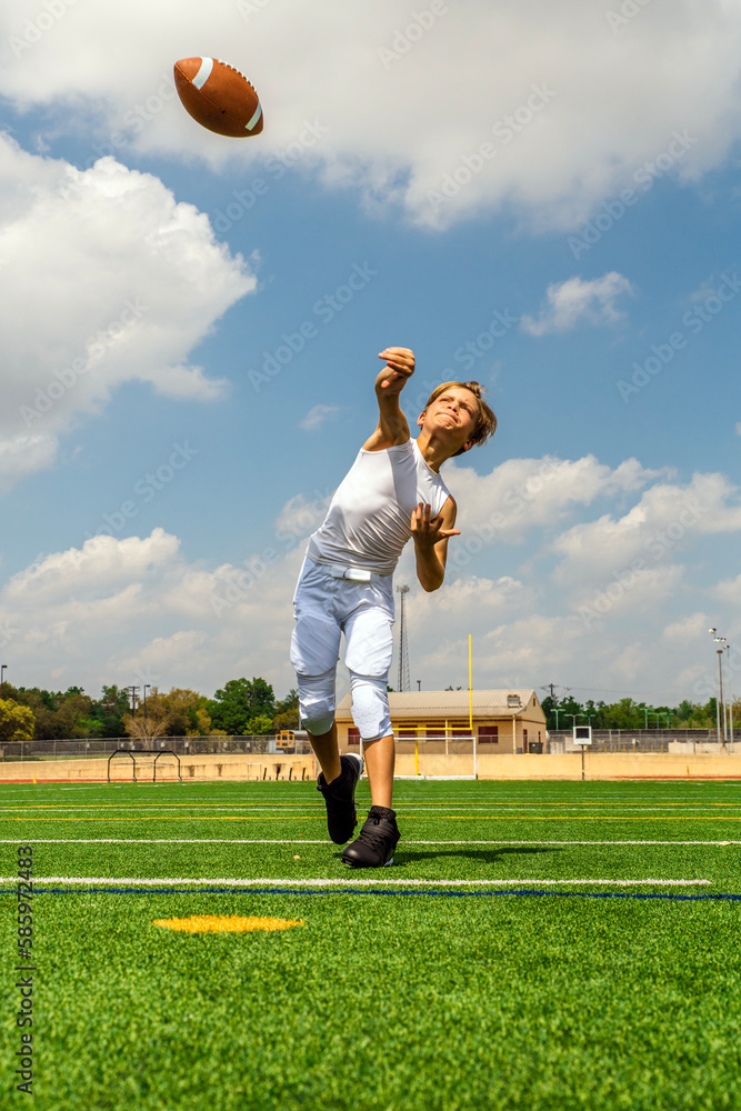 Youth preteen boy football player in uniform with football on football ...