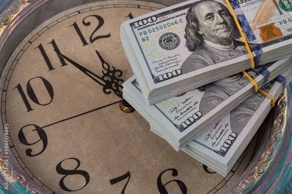 100 American dollar bills and the dial of a large wall clock Stock ...
