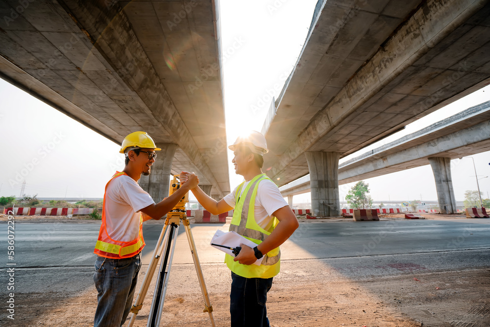 Asian civil engineer team working with theodolite and highway ...