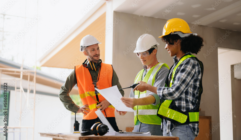 Foto de Contractor and architect looking at plan, tablet, laptop and ...