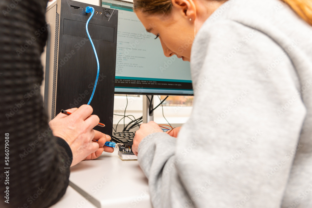 Teacher helping his teen student with diy robot on stem education class.Student In After School ...