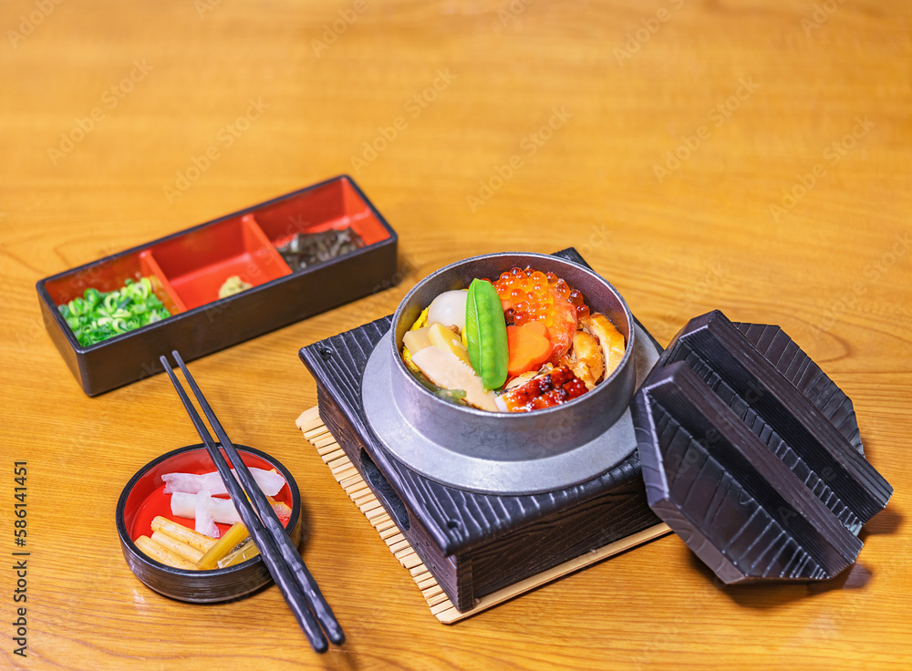 Japanese kamameshi rice dish cooked in an iron kama pot with ikura red ...
