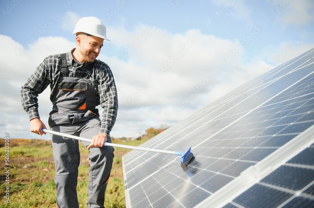 technician operating and cleaning solar panels at generating power of ...