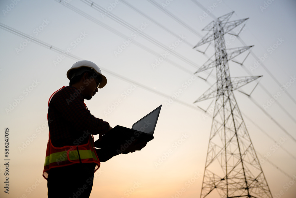 Silhouette of an electrical engineer standing at a power station Use ...