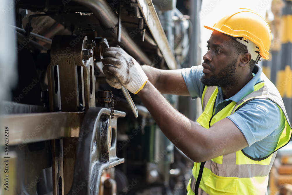 Male engineer maintenance locomotive engine, wearing safety uniform ...